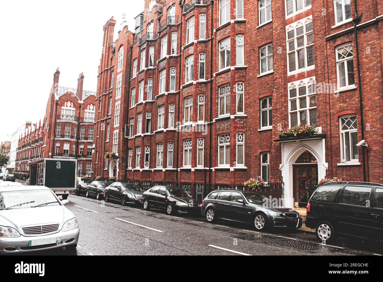 Cars parked on a road next to buildings Stock Photo - Alamy