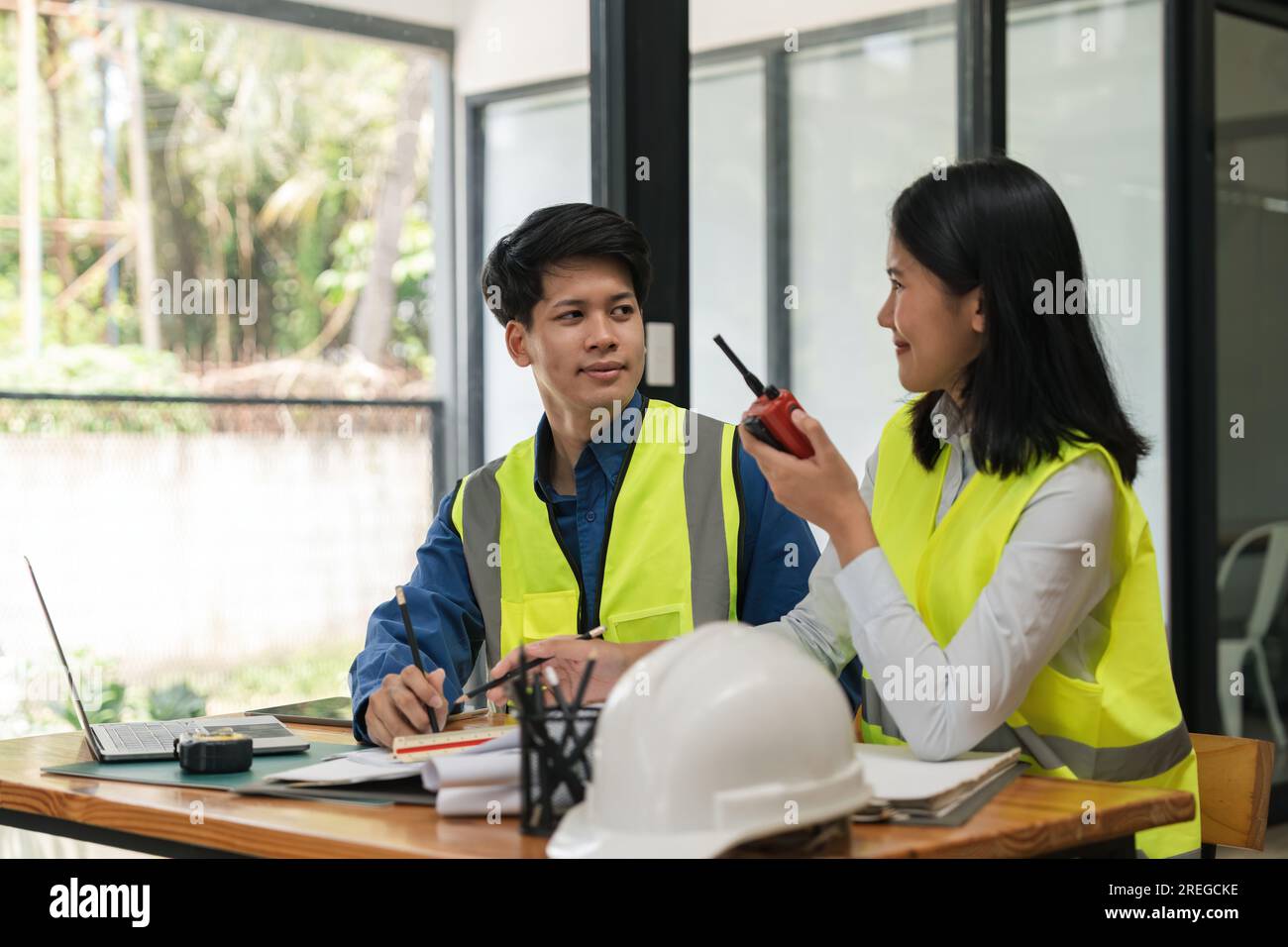 Two young man and woman engineers meeting, working, discussing, planing ...
