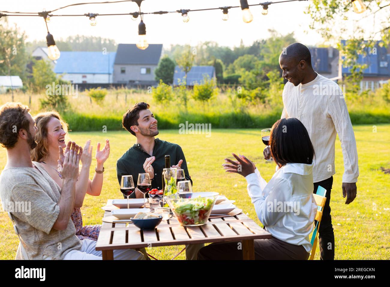 An exuberant scene at a garden dinner party where a black man brings ...