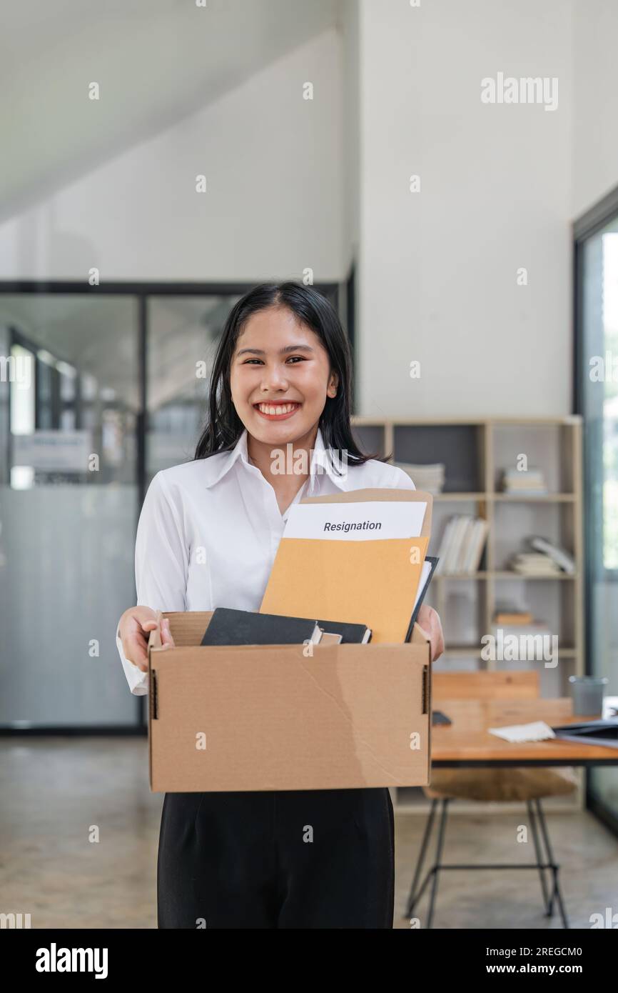 Smiling young Asian female office worker her resignation, carrying her ...
