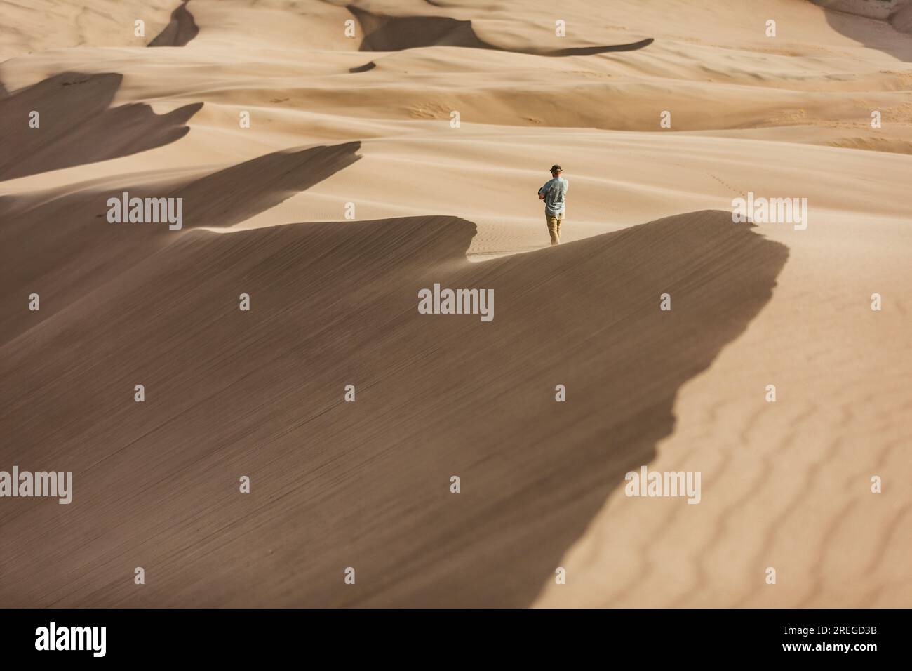 Man walking along sand dunes hi-res stock photography and images - Alamy