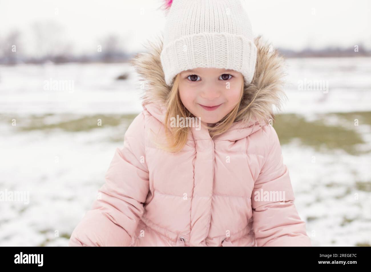 Child with expressive eyes playing outdoors in the winter snow Stock ...
