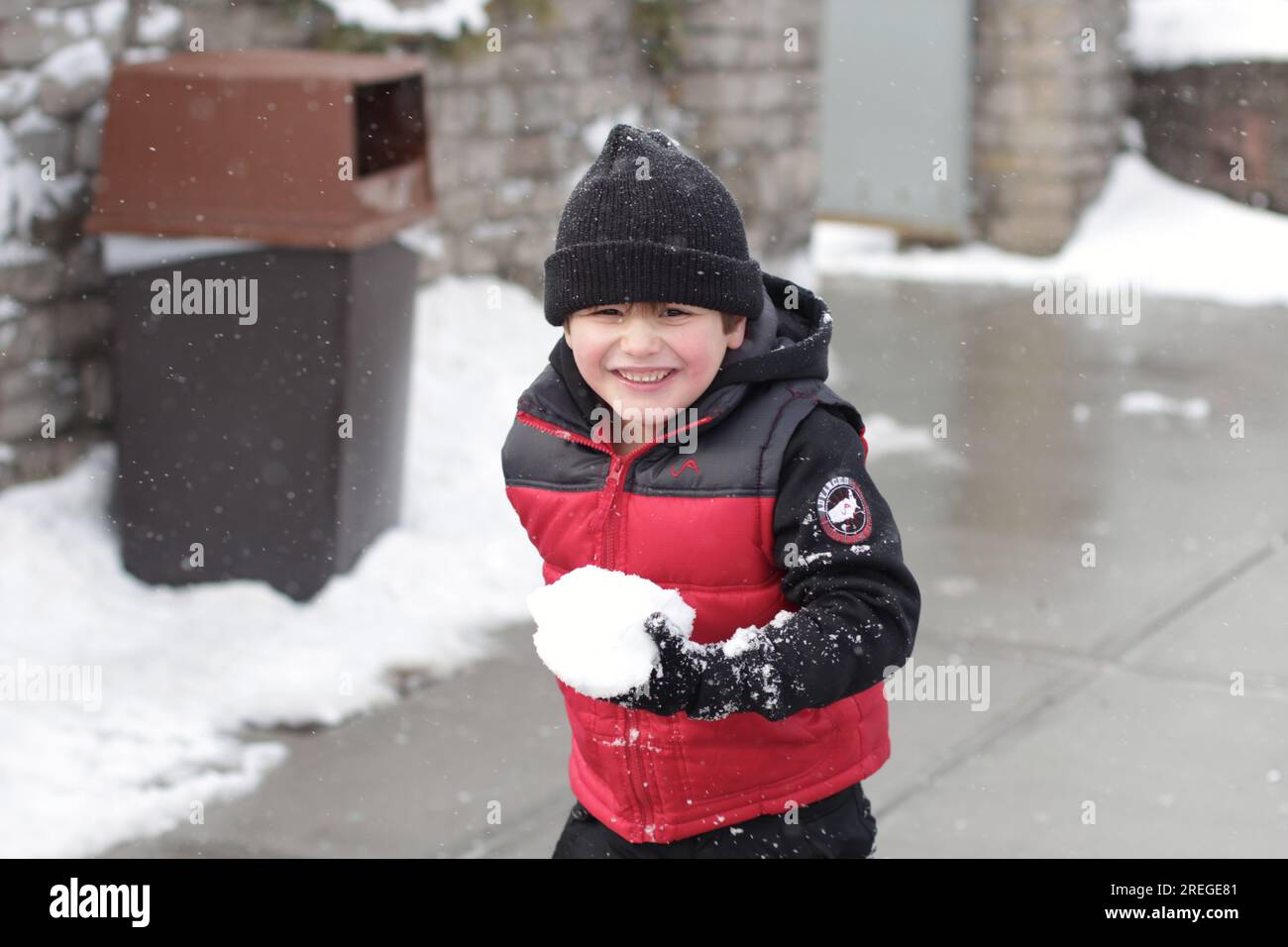 A happy boy with a snowball, playing outside Stock Photo - Alamy