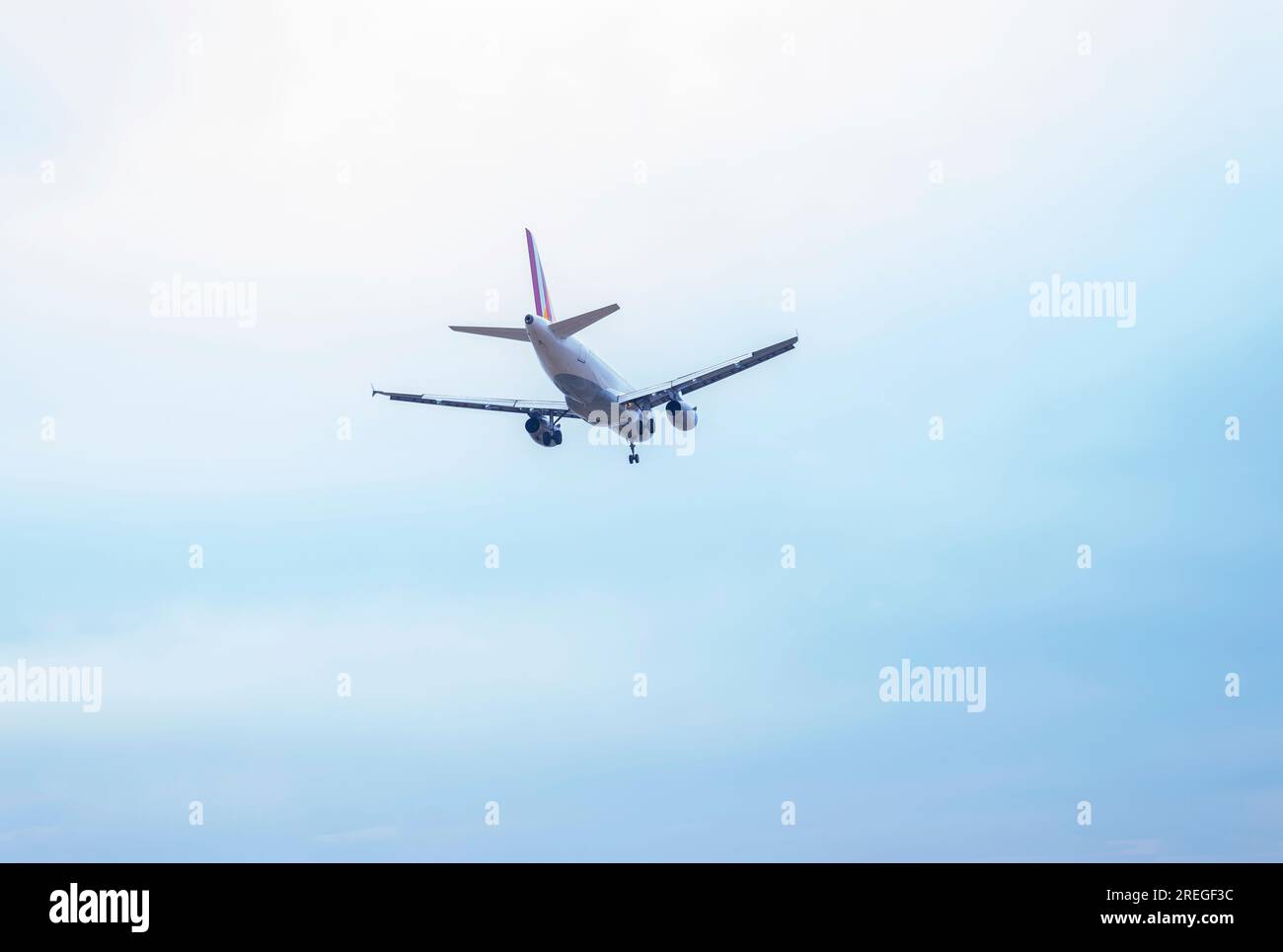 Low angle view of commercial airplane flying in sky with landing gear ...
