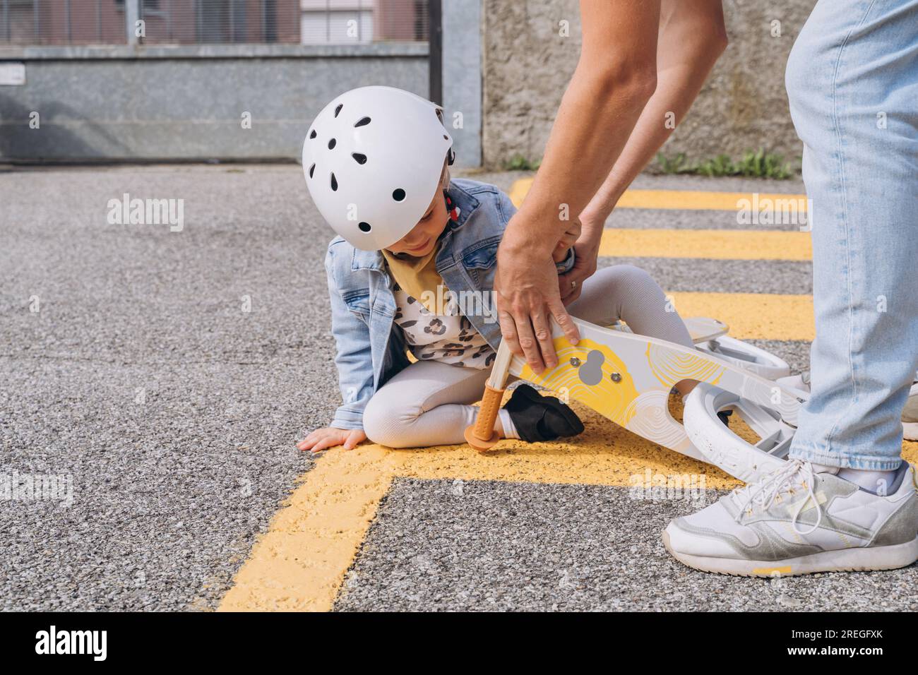 Little girl fell off balance bike dad helps her to get up Stock Photo ...
