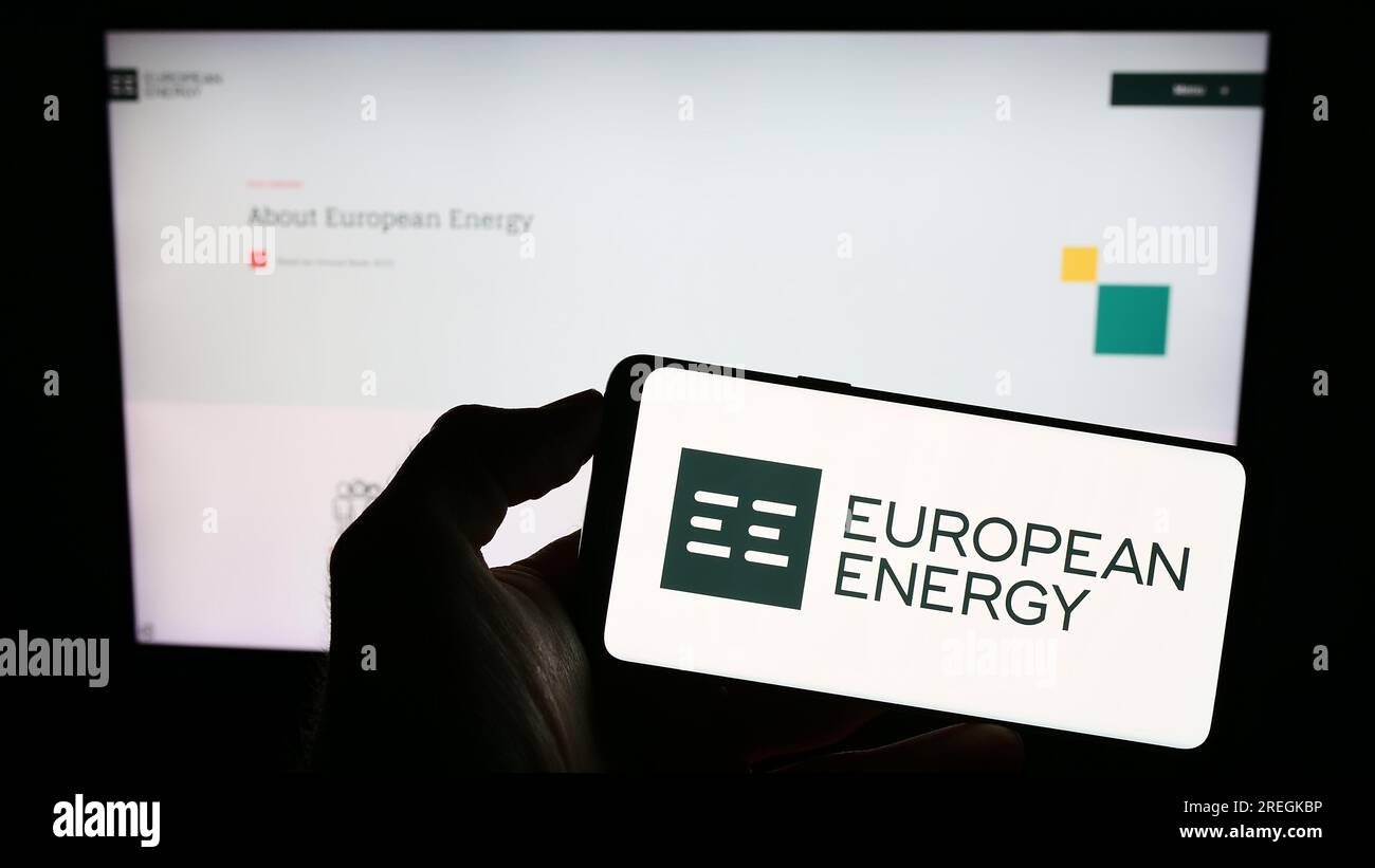 Person holding mobile phone with logo of Danish renewables company ...