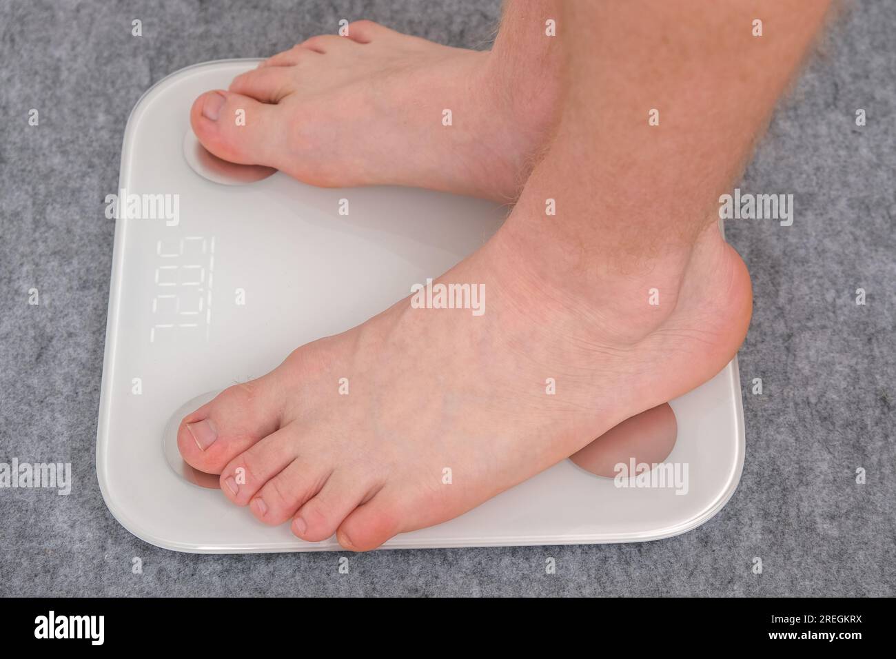 A man stands on the scales. The guy is weighing himself. Floor scales ...