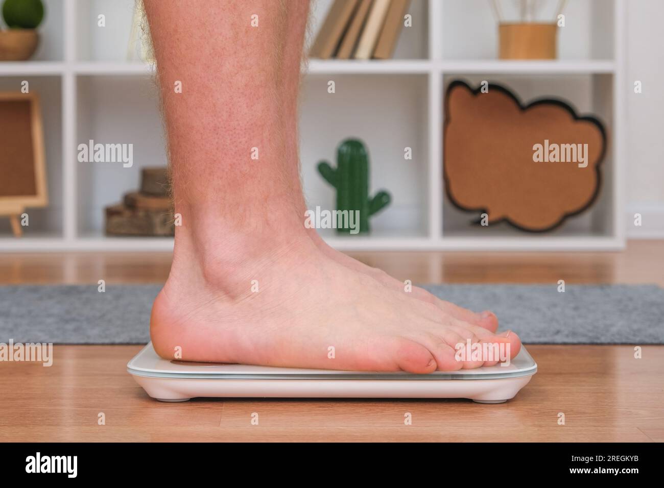 A man stands on the scales. The guy is weighing himself. Floor scales ...