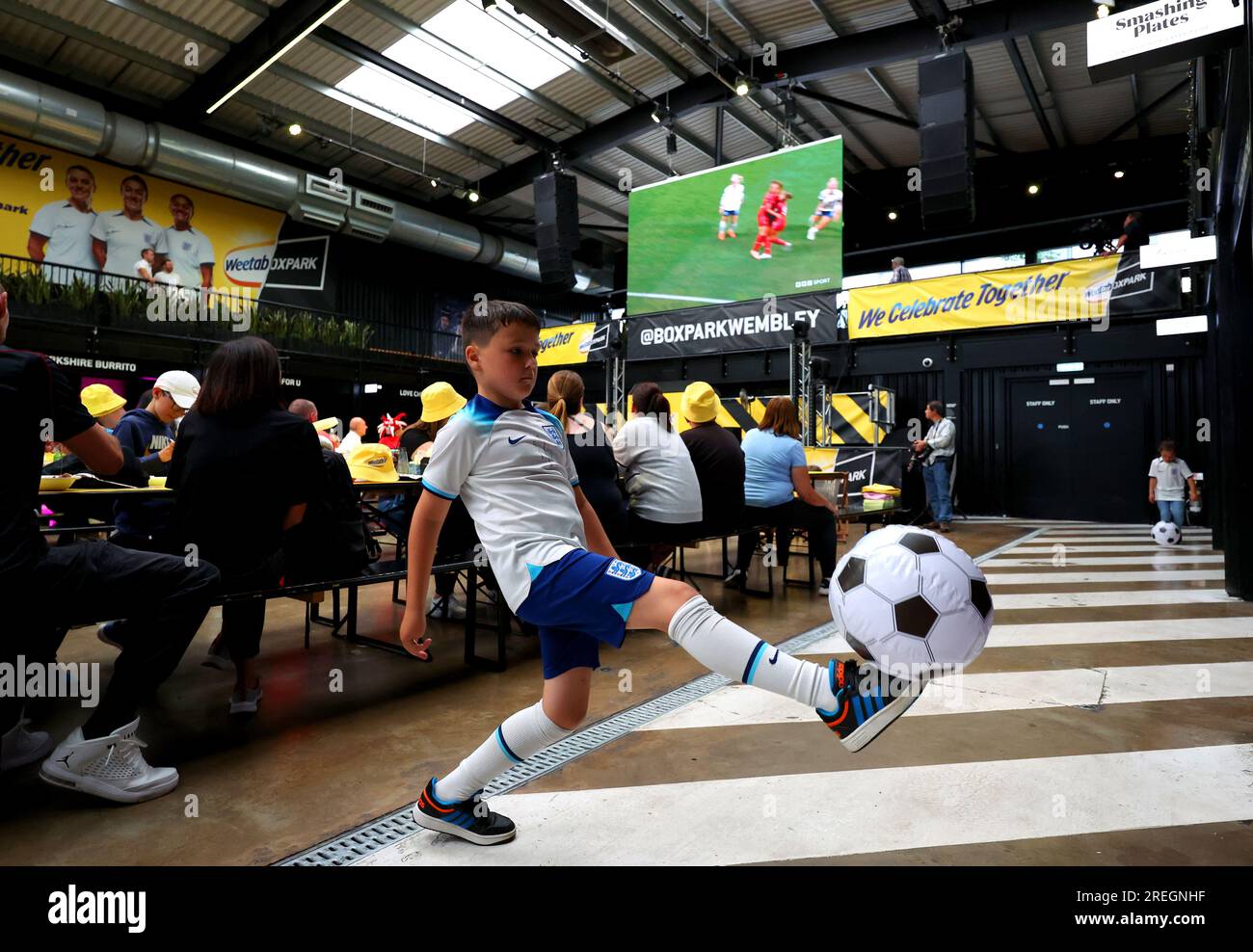 An England fan plays with an inflatable football whilst watching a ...