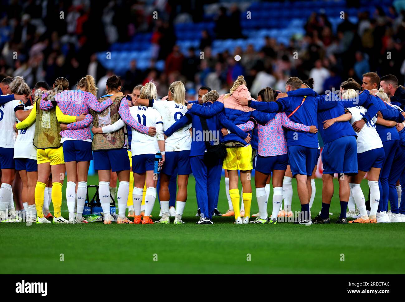 England players and staff members huddle together on the pitch at the ...