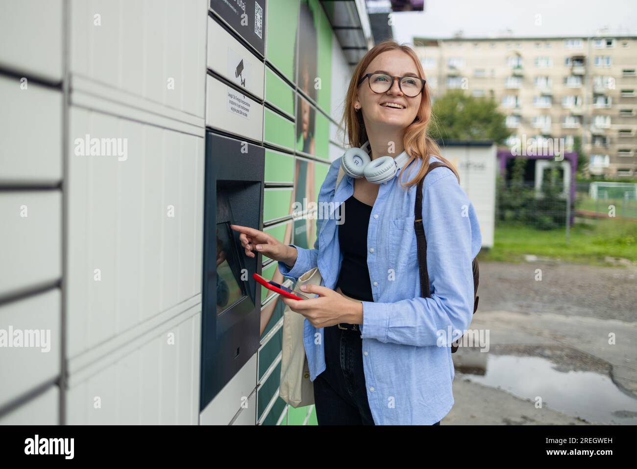 Woman client using automated self service post terminal machine or ...