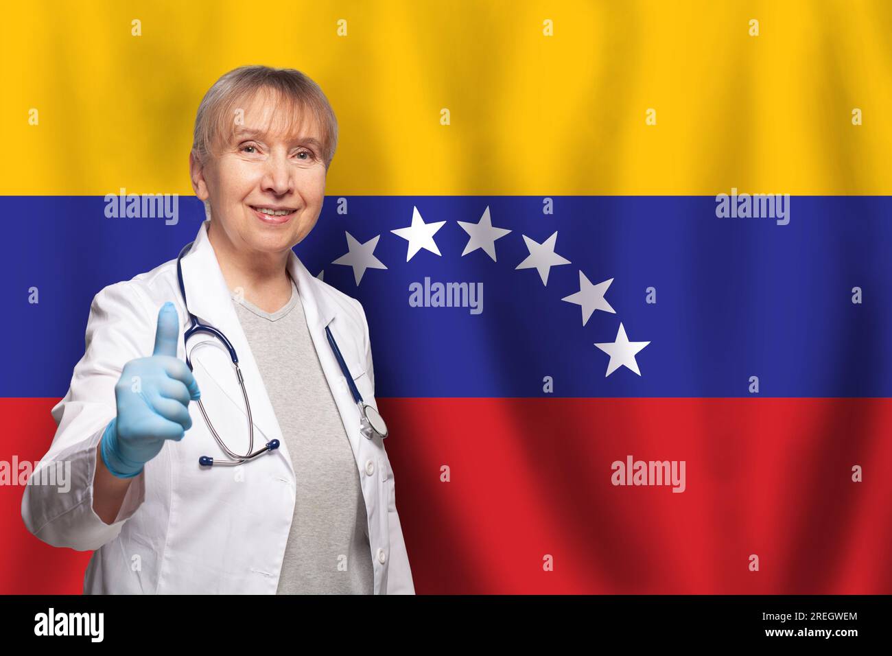 Venezuelan smiling mature doctor woman holding stethoscope on flag of ...