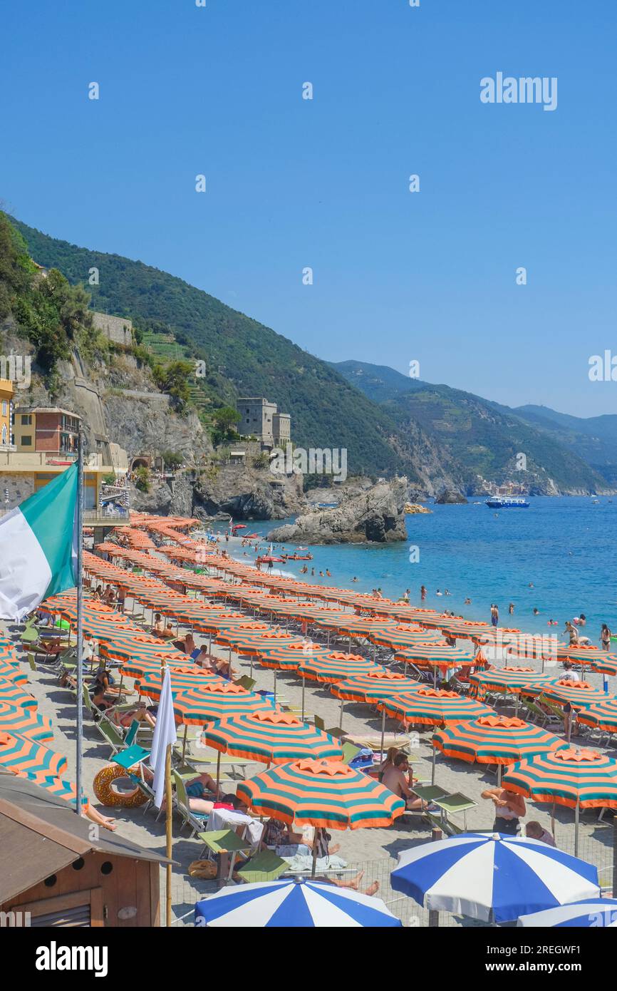 orange beach umbrellas on the beach of Monterosso, Cinque Terre, The Ligurian Sea, Liguria ...