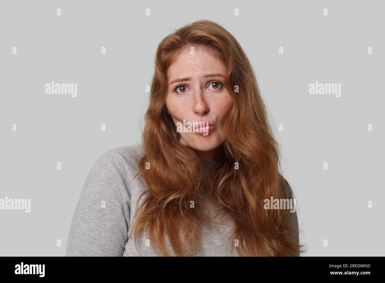 Cute woman grimacing, studio portrait Stock Photo - Alamy