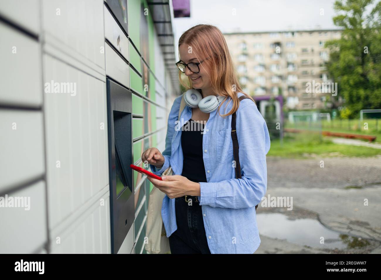 Woman client using automated self service post terminal machine or ...