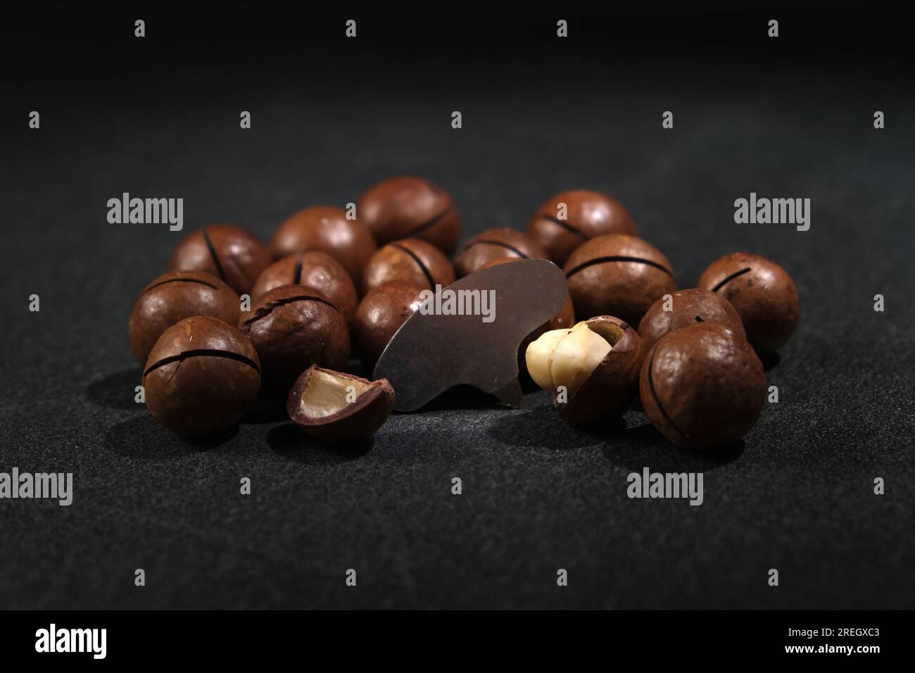 Macadamia nuts with a key on a black background Stock Photo - Alamy