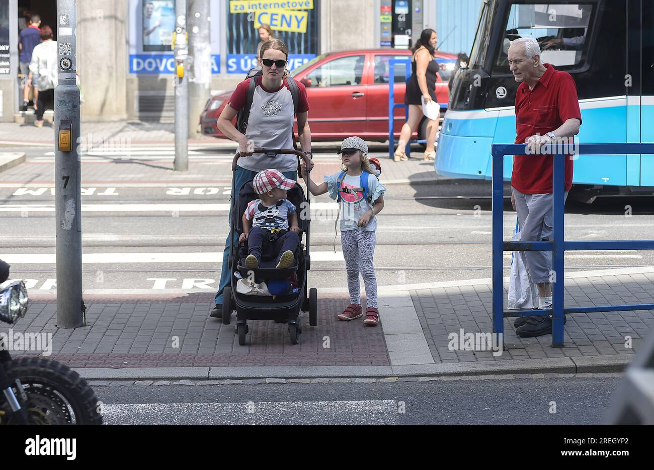 Mother with her children and pram crossing road in the city center of ...