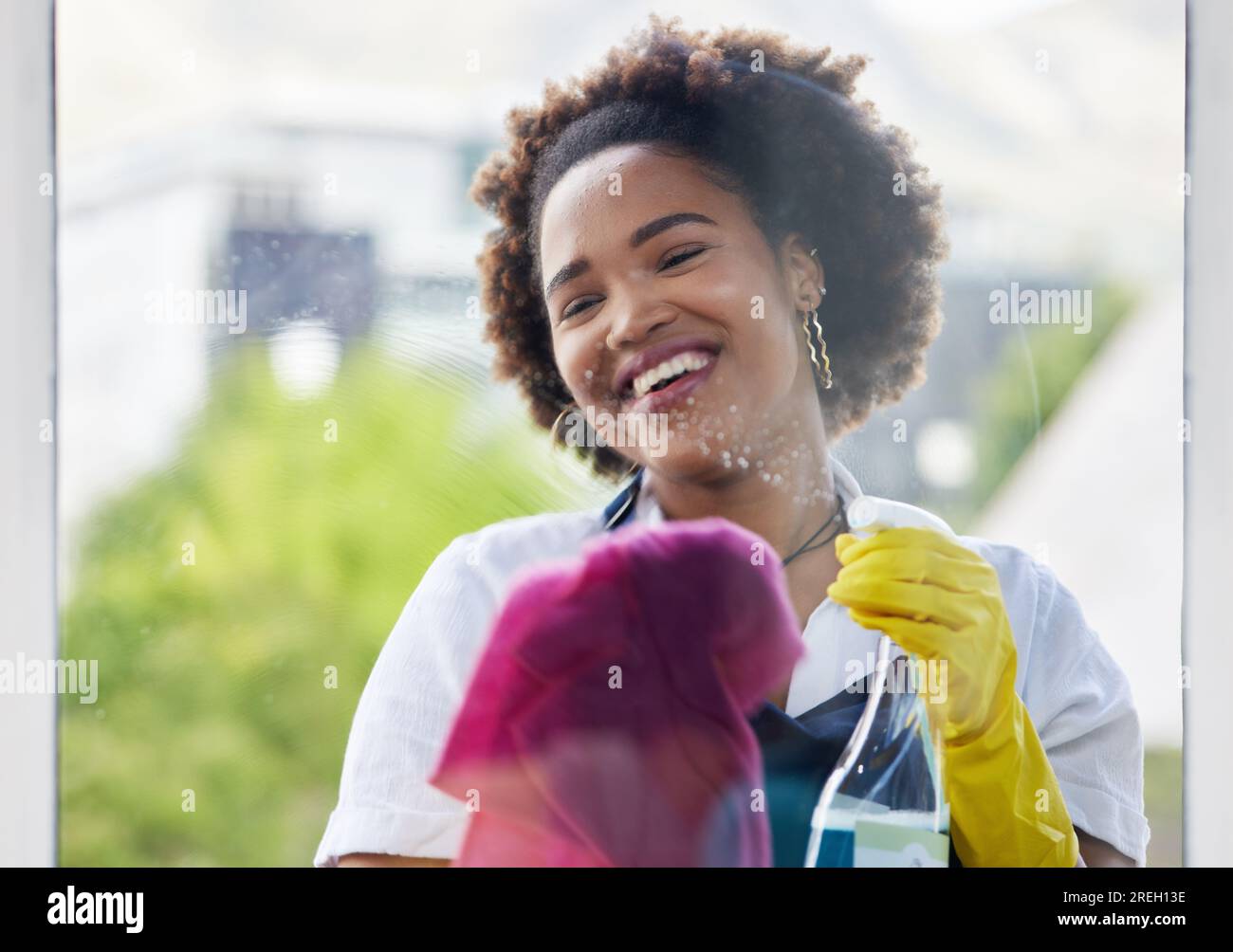 Black woman, cleaning spray and bottle on windows with cloth for ...