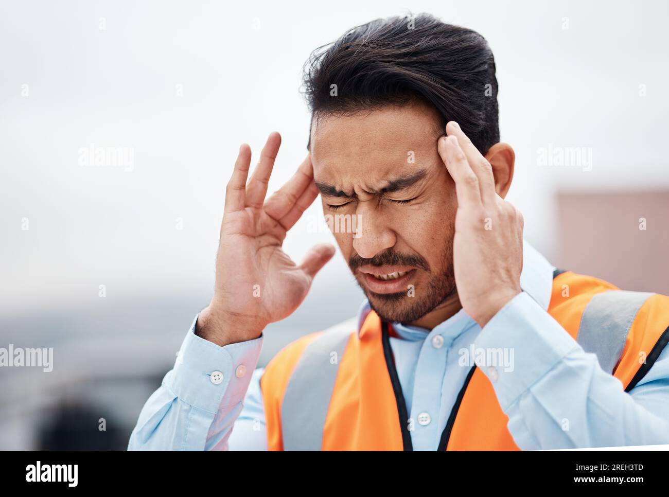 Headache, stress and male construction worker on a rooftop of a ...