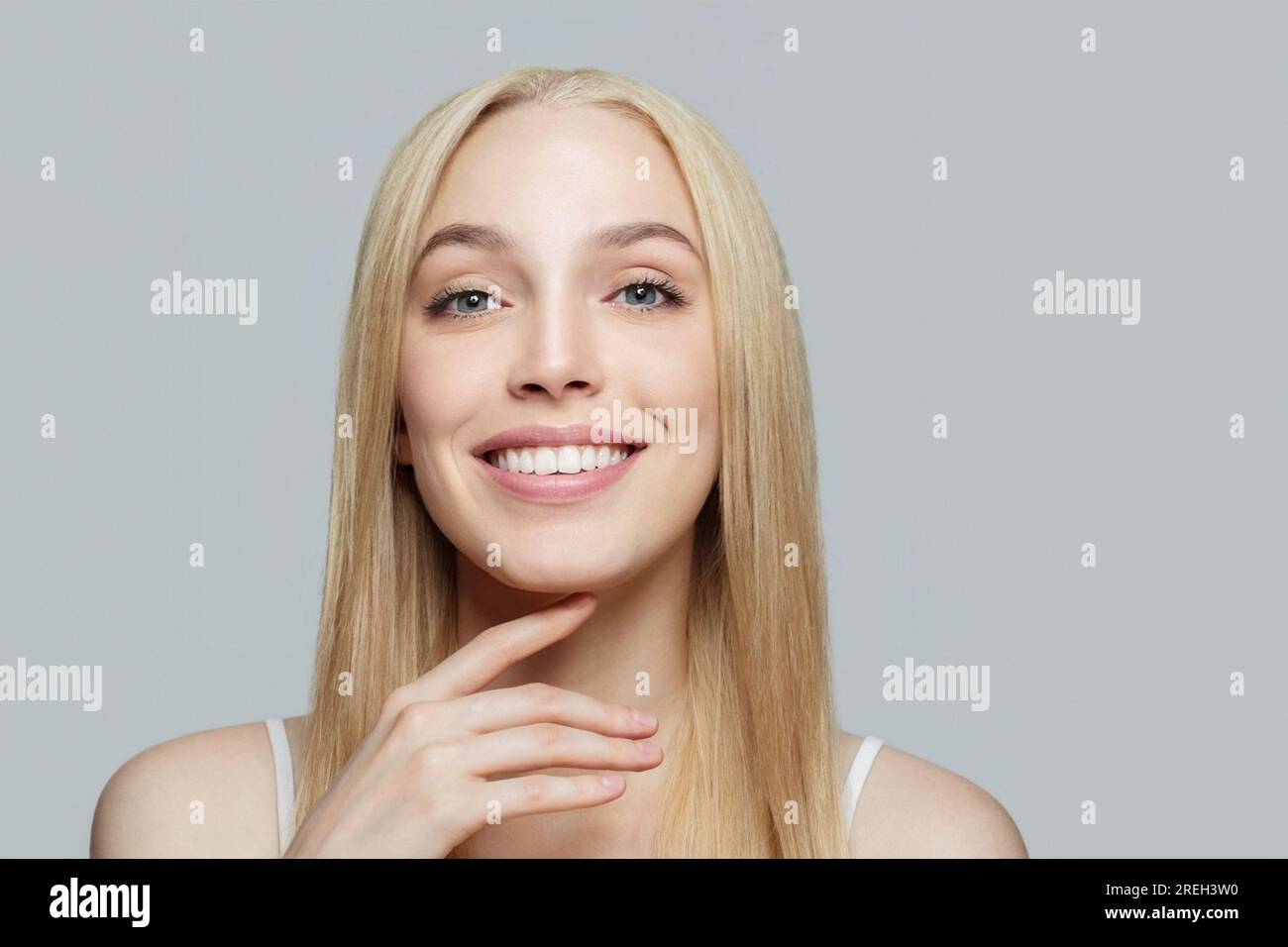 Beautiful blonde woman touching her face her hand. Pretty candid female ...