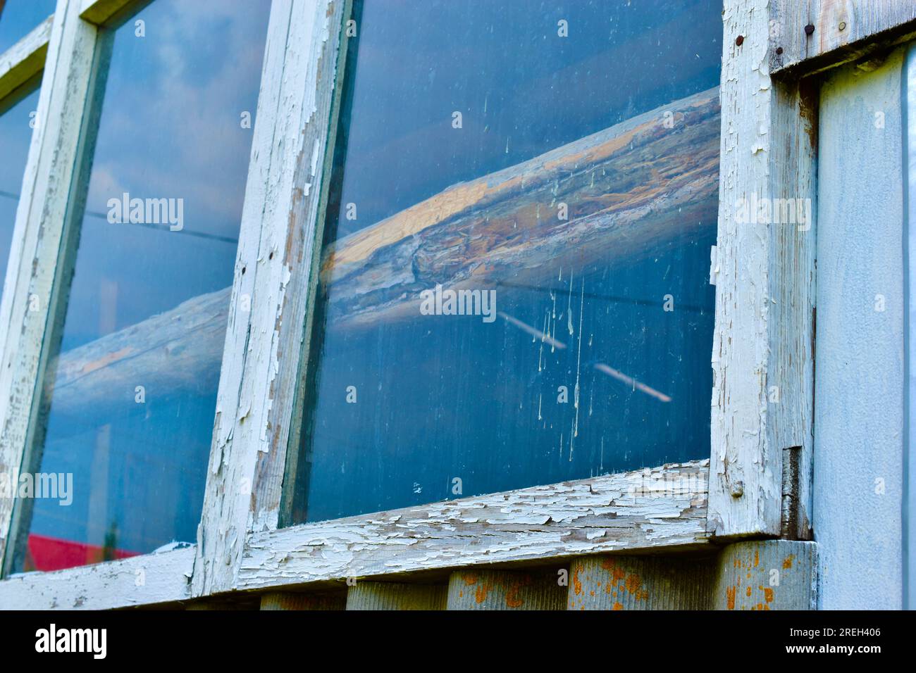 An old glass window with peeling paint into a log shed Stock Photo - Alamy