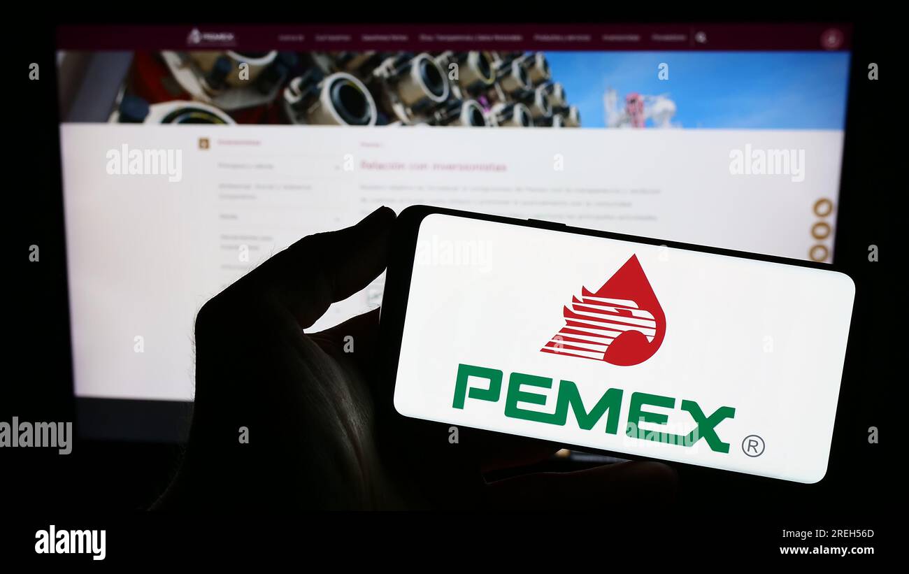 Person holding mobile phone with logo of oil company Petroleos ...