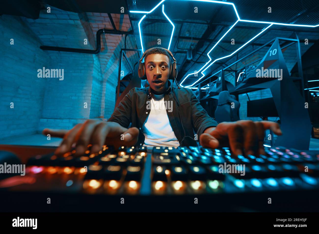 Computer gamer with hands on keyboard very emotional and surprised ...