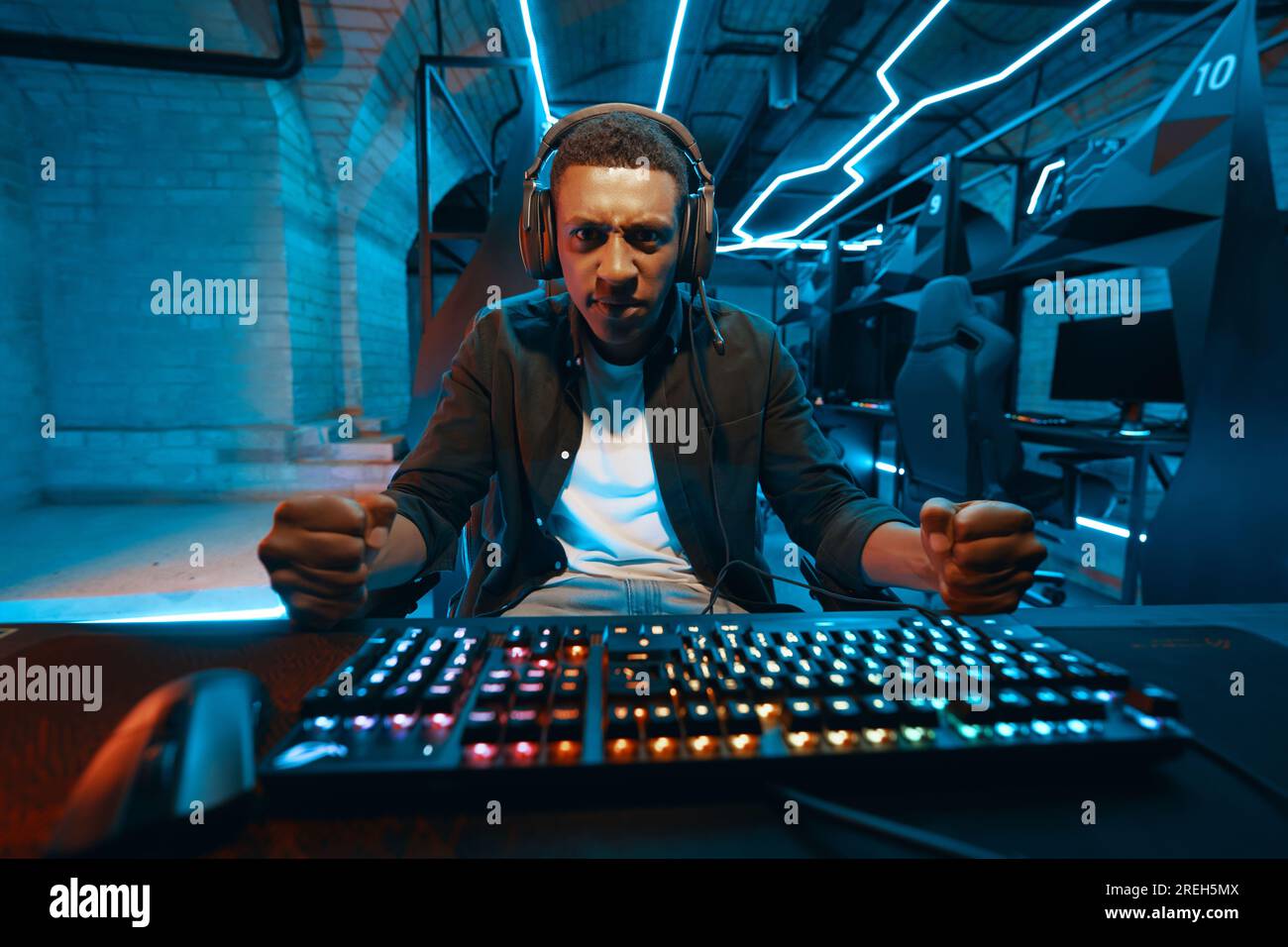 Computer gamer with hands on keyboard very emotional and surprised ...