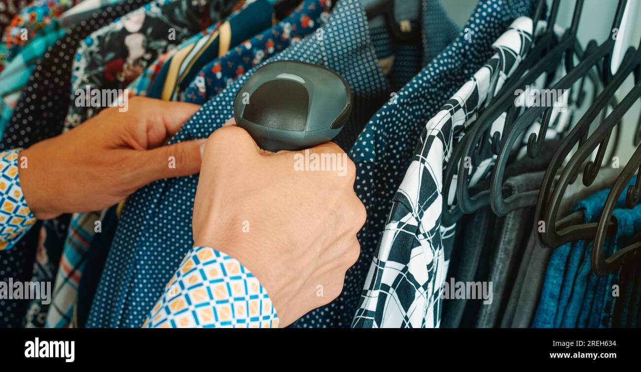 a man in a clothes shop using a barcode scanner to scan the information ...