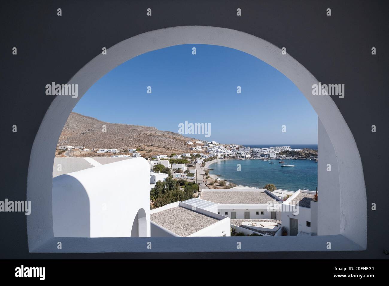 Folegandros port, with white buildings around the water, viewed through ...