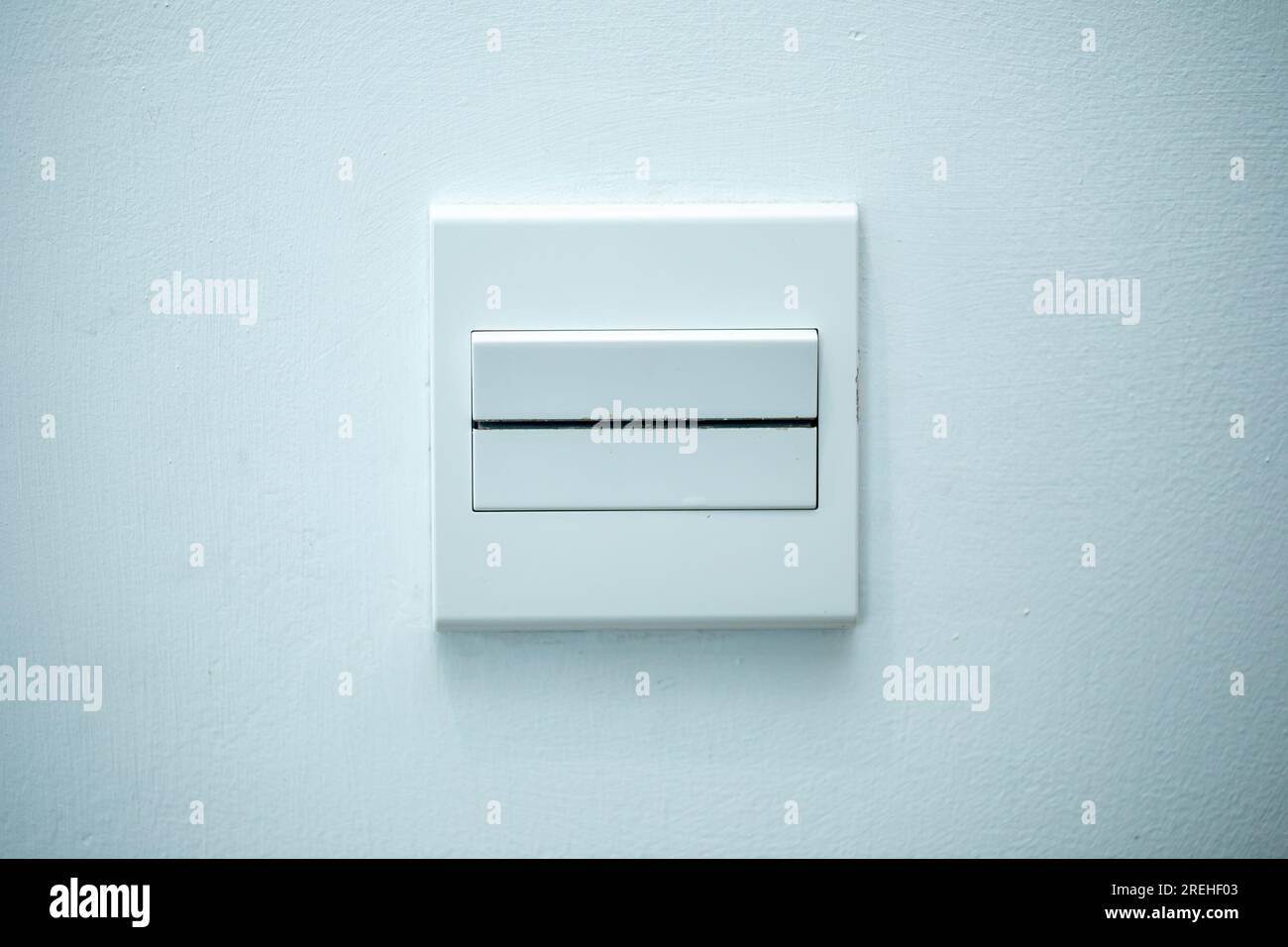 Long flat white on-off switch attached to white wall. White background ...
