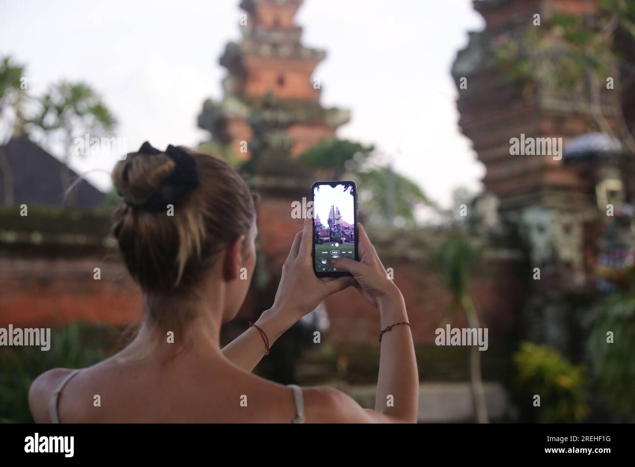 Tourist woman taking photo of Balinese temple with phone Stock Photo ...