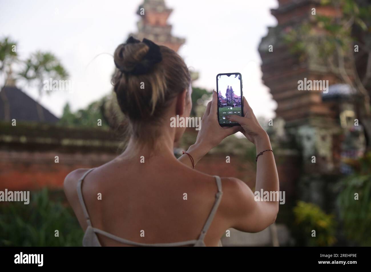 Tourist woman taking photo of Balinese temple with phone Stock Photo ...