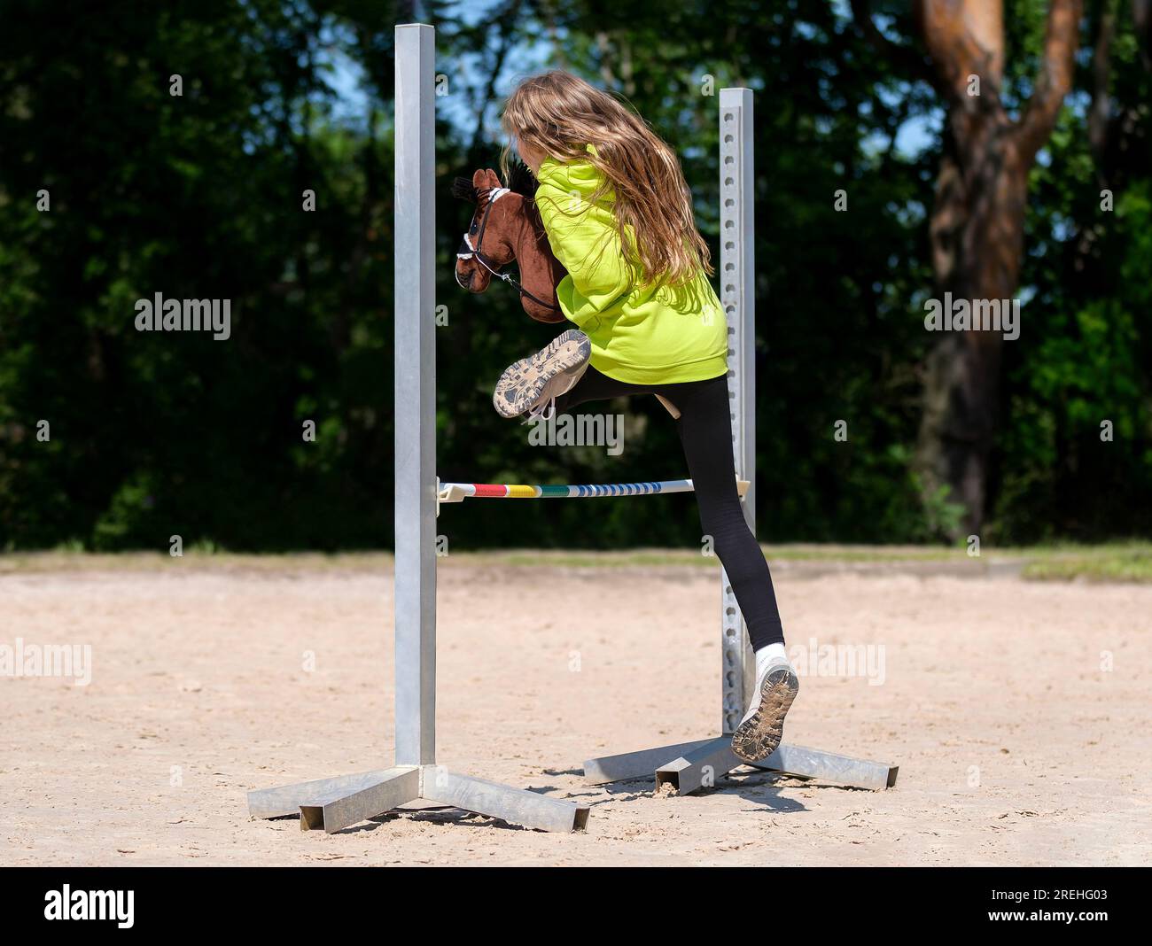 Girl jumping on hobby horse. Champion. Horse sport. Summer light. Green ...
