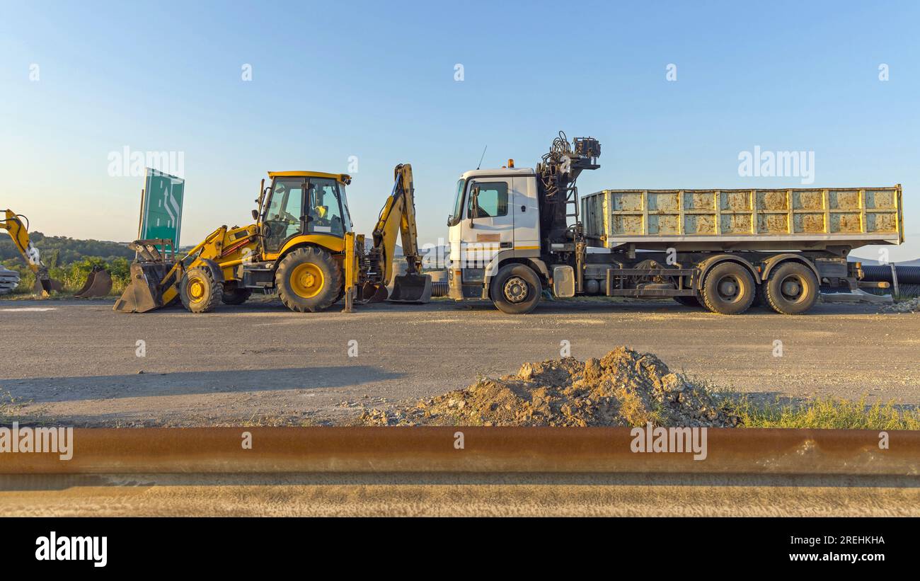 Backhoe Loader Machine and Dump Tipper Truck Highway Construction Site ...