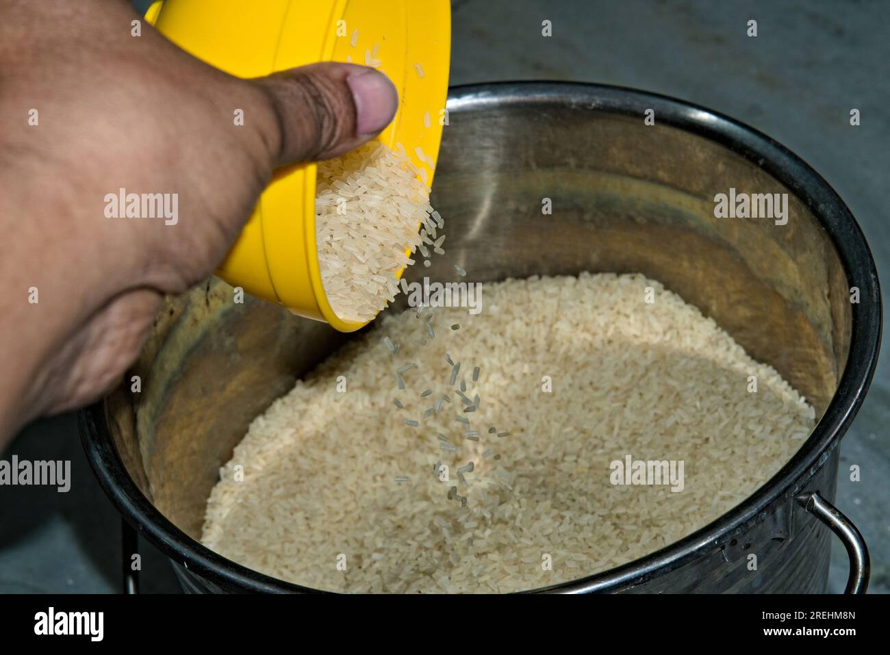 pouring basmati rice in a bucket with the help of plastic cup Stock ...