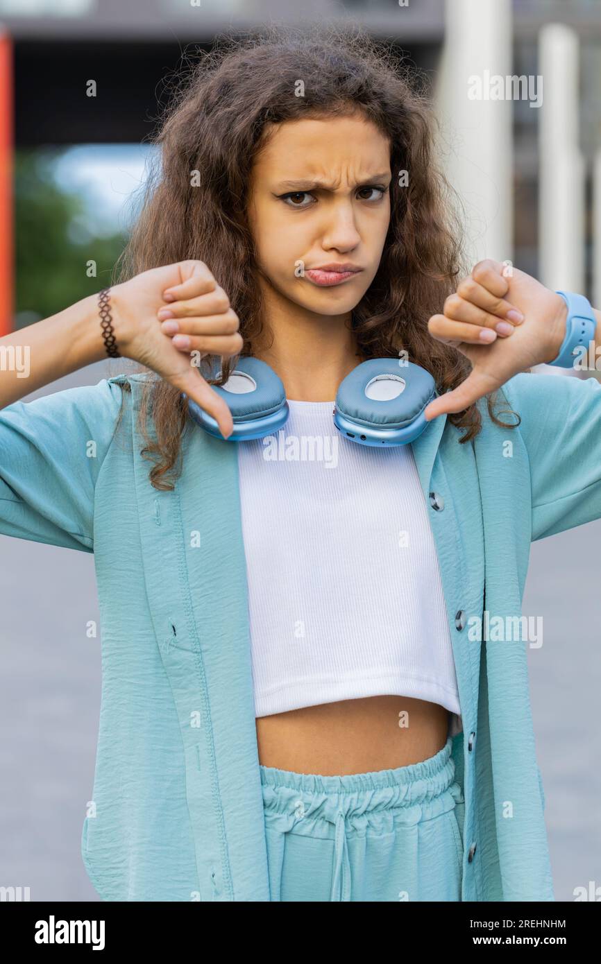 Dislike. Upset preteen child kid showing thumbs down sign gesture ...