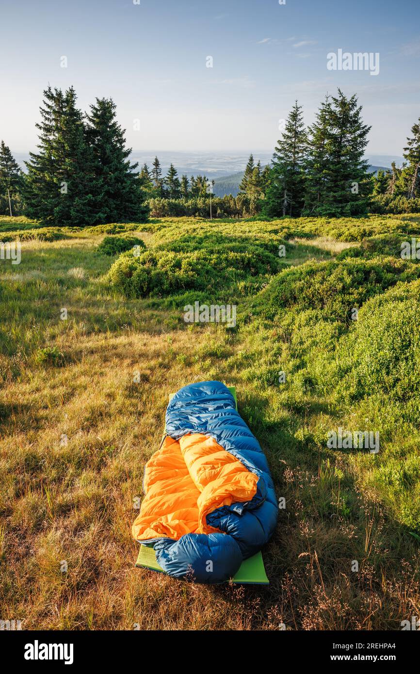 Open sleeping bag on mat at mountains. Bivouac and camping outdoors ...