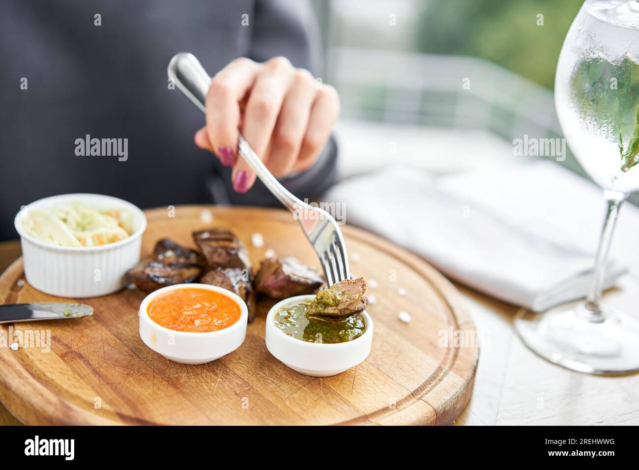 Lunch in a restaurant, a woman eats Pieces of liver cooked on the grill ...
