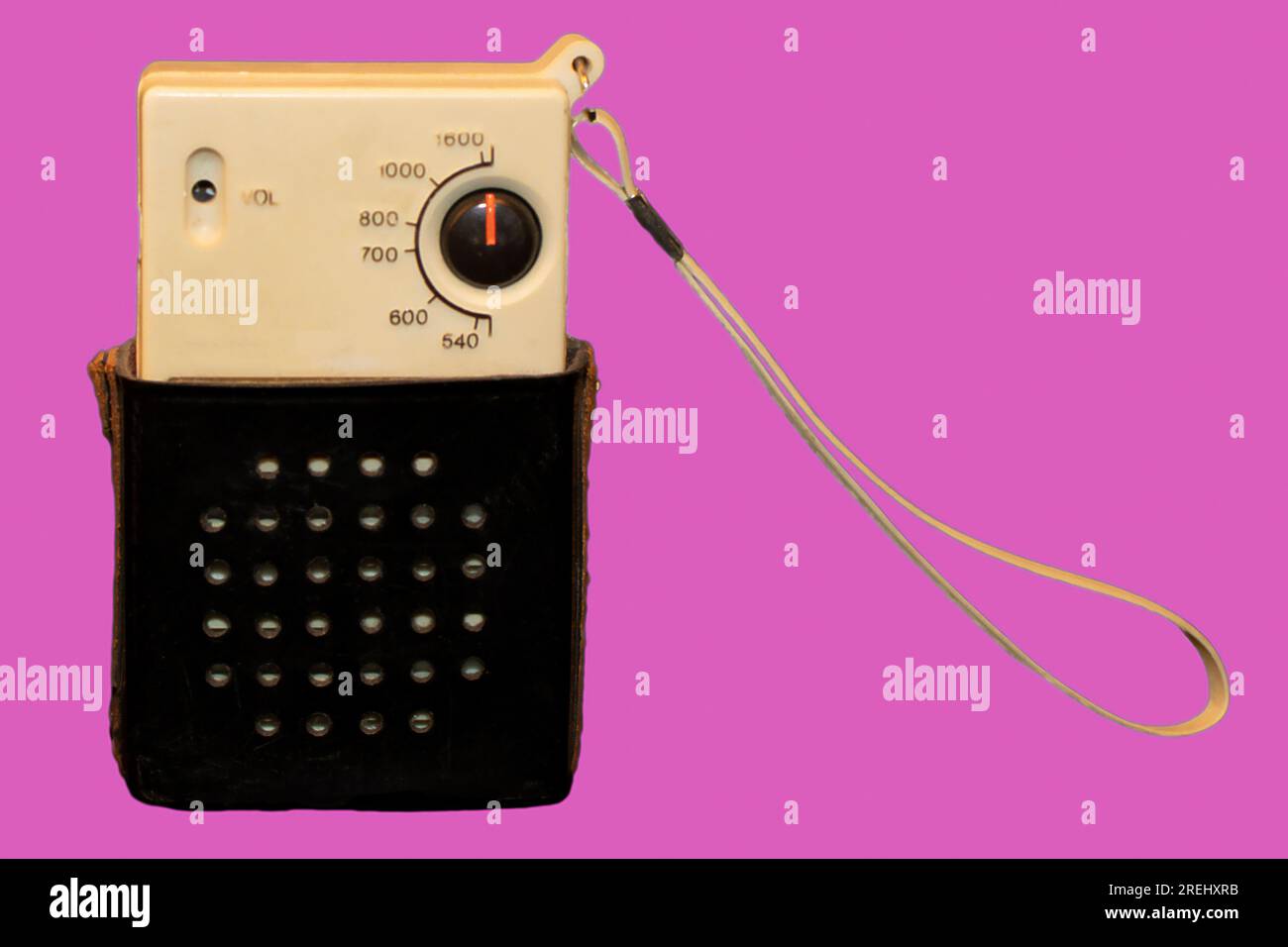 Vintage 1960's style AM transistor radio with hand strap on a pink ...