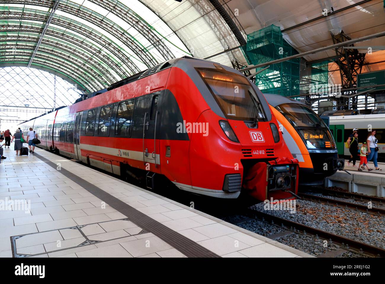 Red railway wagon train. A modern high speed train stands at Dresden ...