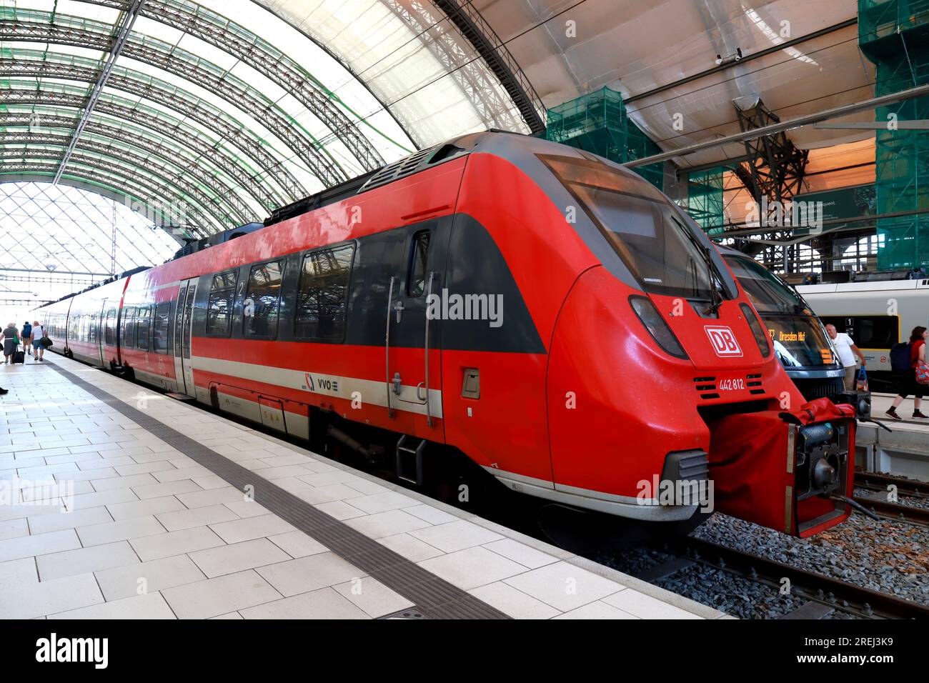 Red railway wagon train. A modern high speed train stands at Dresden ...