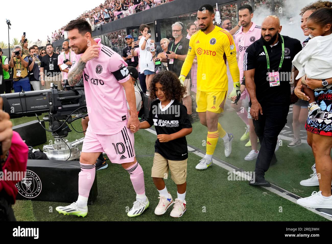Inter Miami forward Lionel Messi, left, walks onto the field with Asahd ...