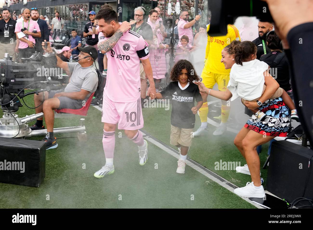 Inter Miami forward Lionel Messi, left, walks onto the field with Asahd ...