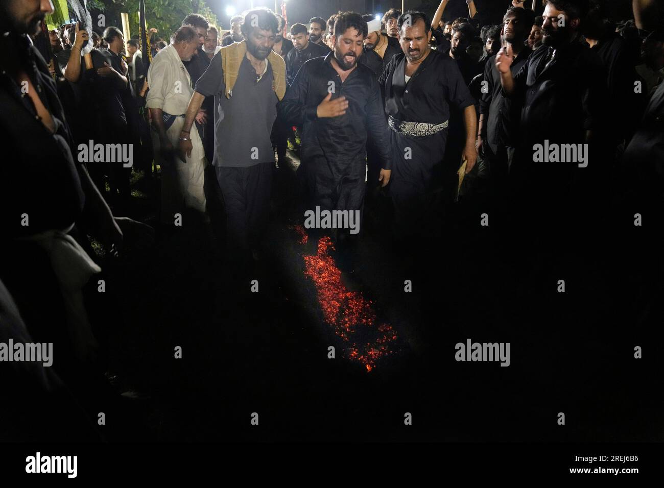 A Pakistani Shiite Muslim walks on burning coal to mourn the death of ...