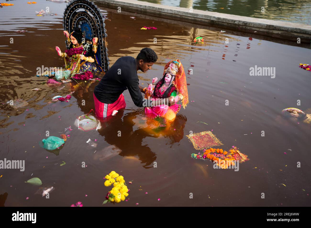A man immerses an idol of Hindu goddess Dashama in River Sabarmati in ...
