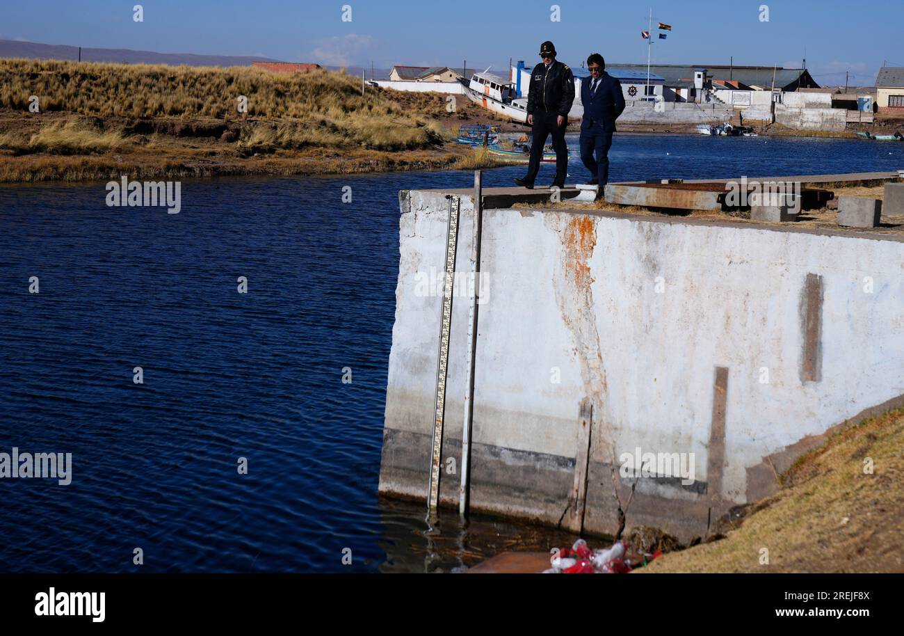 A military officer and an engineer stand near a water gauge that ...