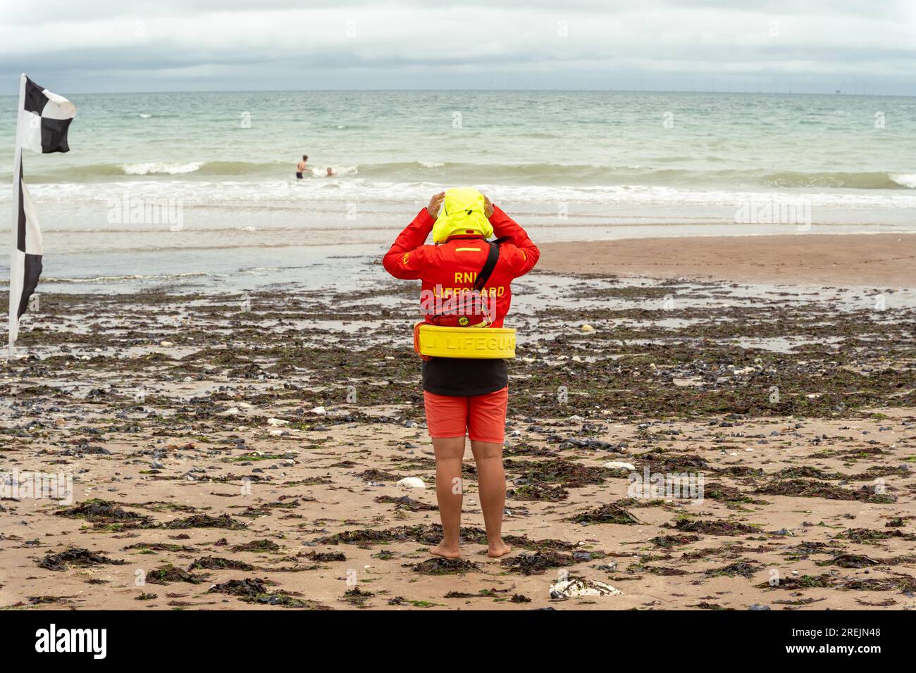 A lifeguard watches as two young boys play in the sea, Margate, Kent ...
