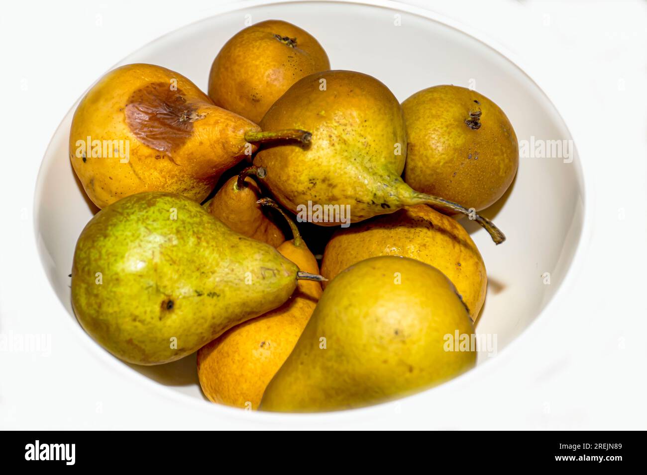 Spoiled pears in a white bowl. Pears in a bowl, isolated on a white ...