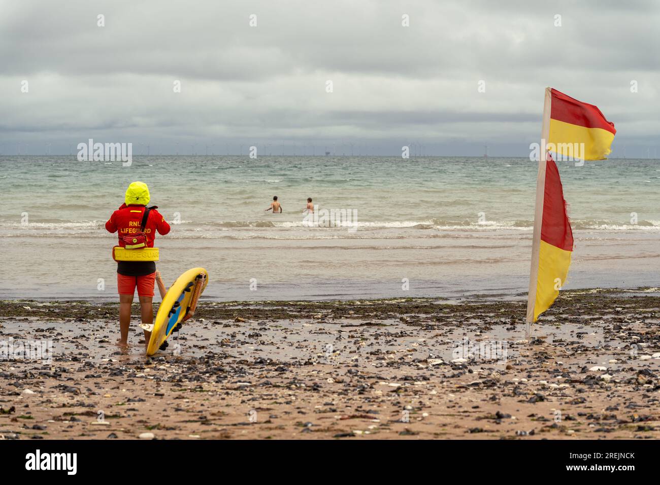 A lifeguard watches as two young boys play in the sea, Margate, Kent ...